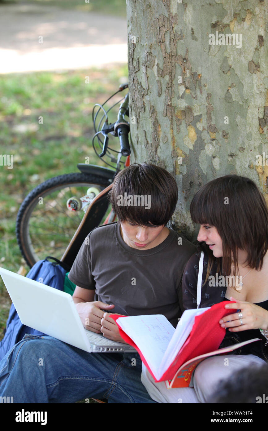 Teenagers friends sitting under tree hi-res stock photography and ...