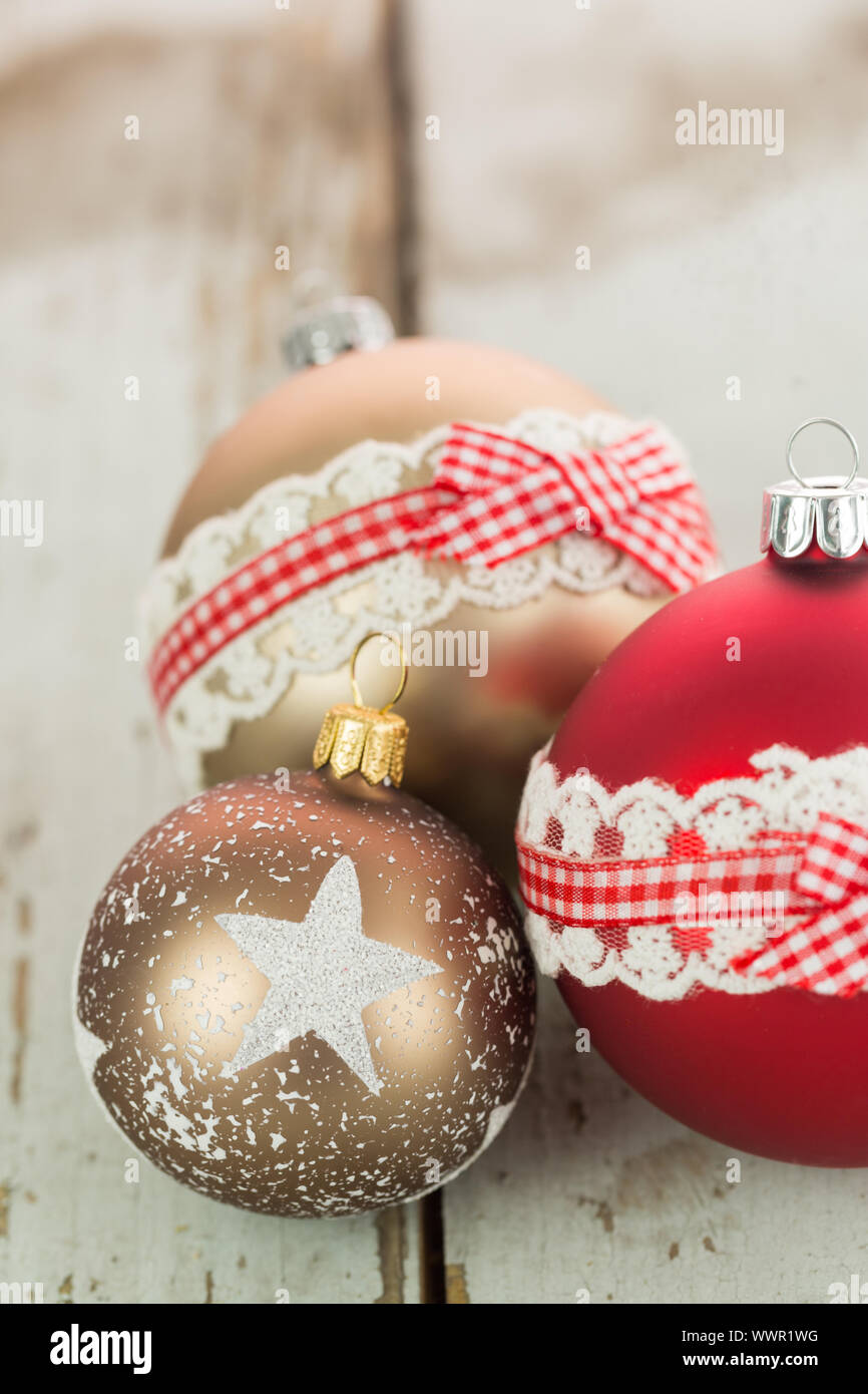 Three Christmas baubles on rustic wood Stock Photo - Alamy