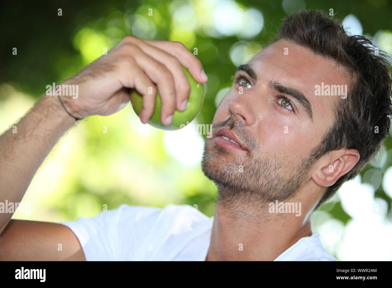 Man eating apple under tree hi-res stock photography and images - Alamy