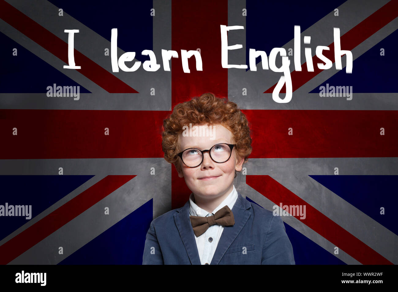 Pretty child boy in school uniform and glasses against the UK flag ...