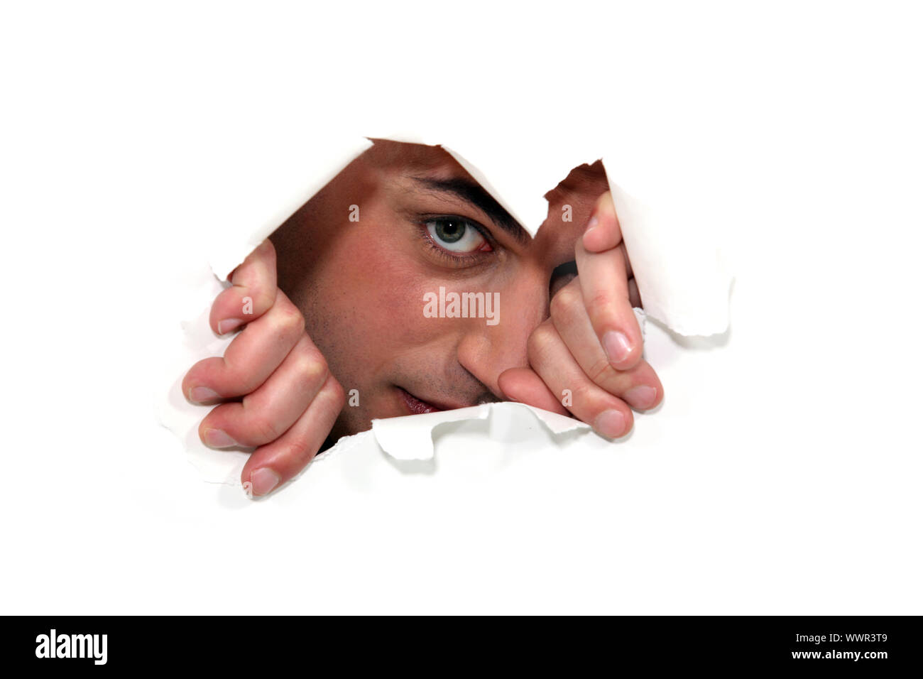 Man looking through a ripped paper wall Stock Photo - Alamy