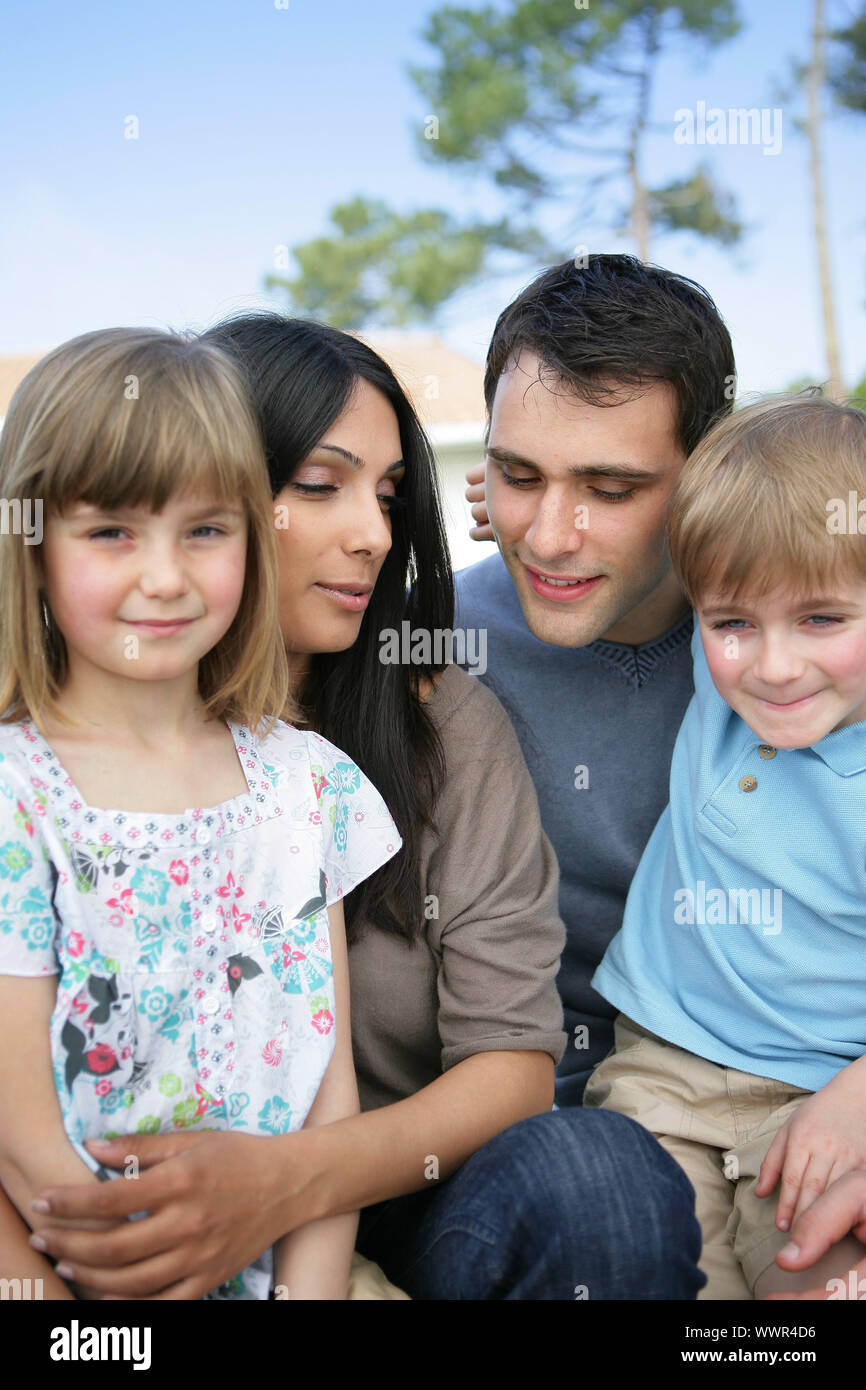 Family sat together in the garden Stock Photo - Alamy