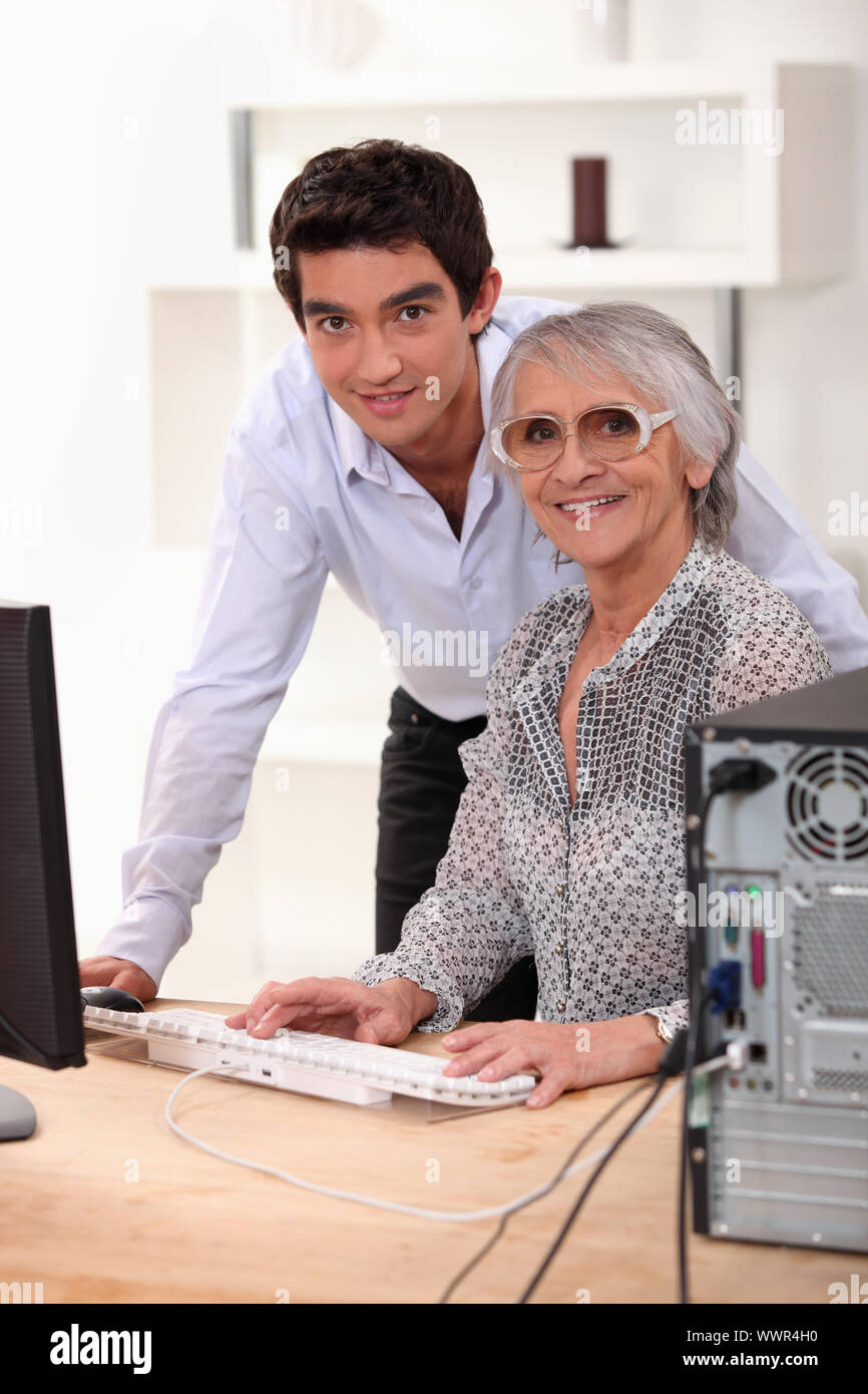 grandson explaining to his grandmother how to use a computer Stock ...