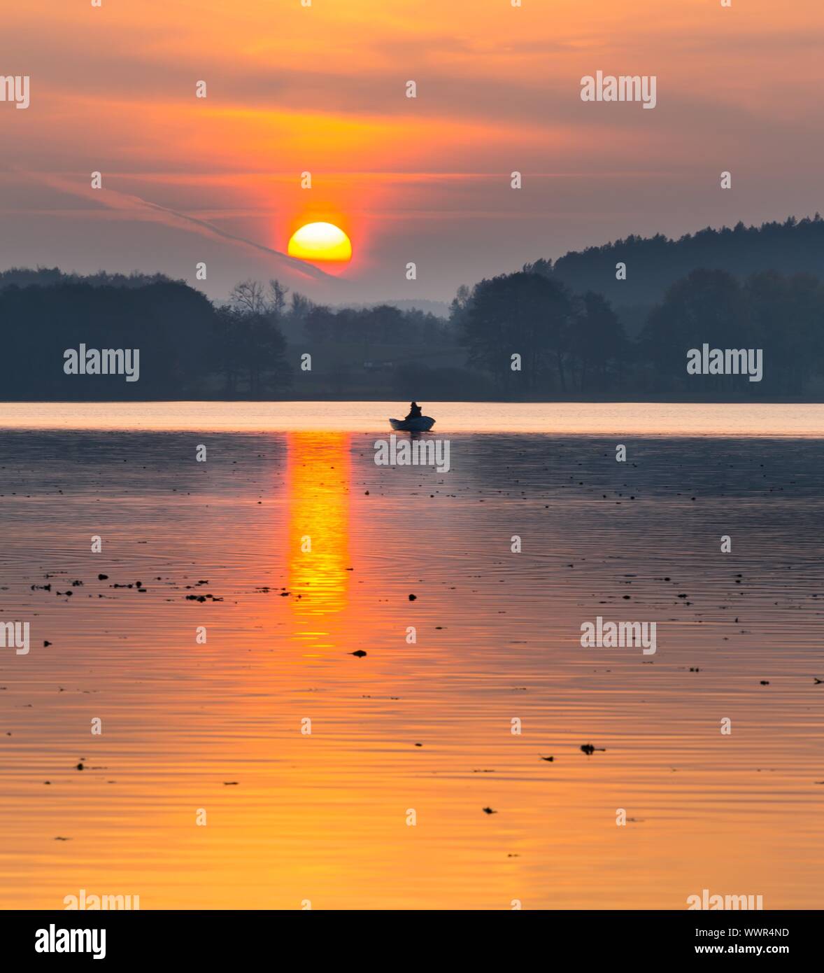 Beautiful lake landscape with fisherman boat and sunset sky. Typical ...