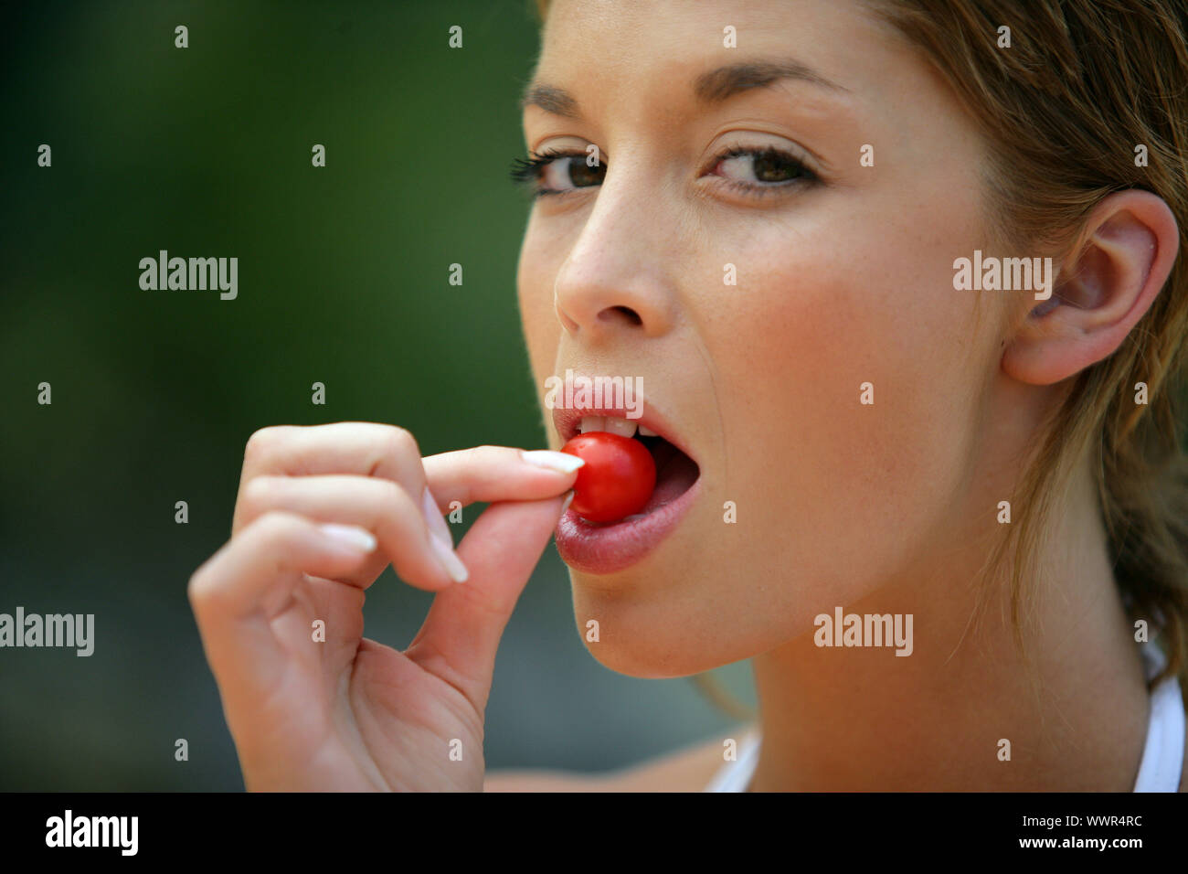 Woman eating a cherry Stock Photo - Alamy