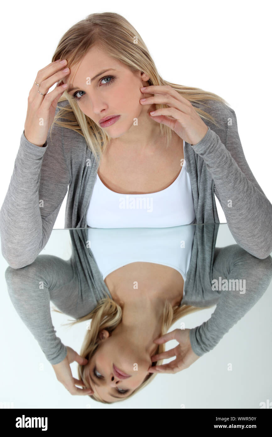 beautiful woman sitting on a mirror table Stock Photo - Alamy