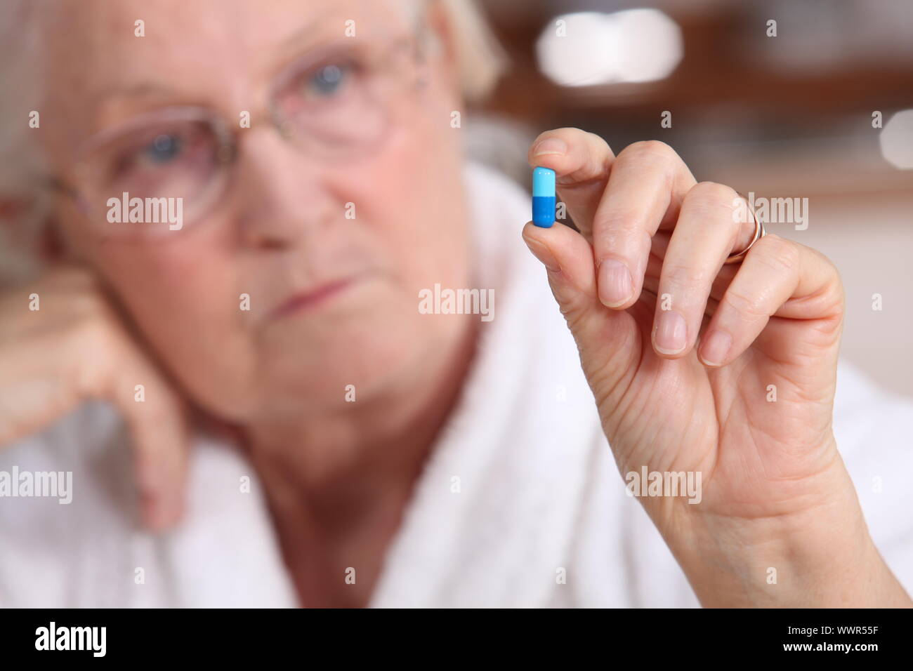 An old woman taking a pill Stock Photo - Alamy
