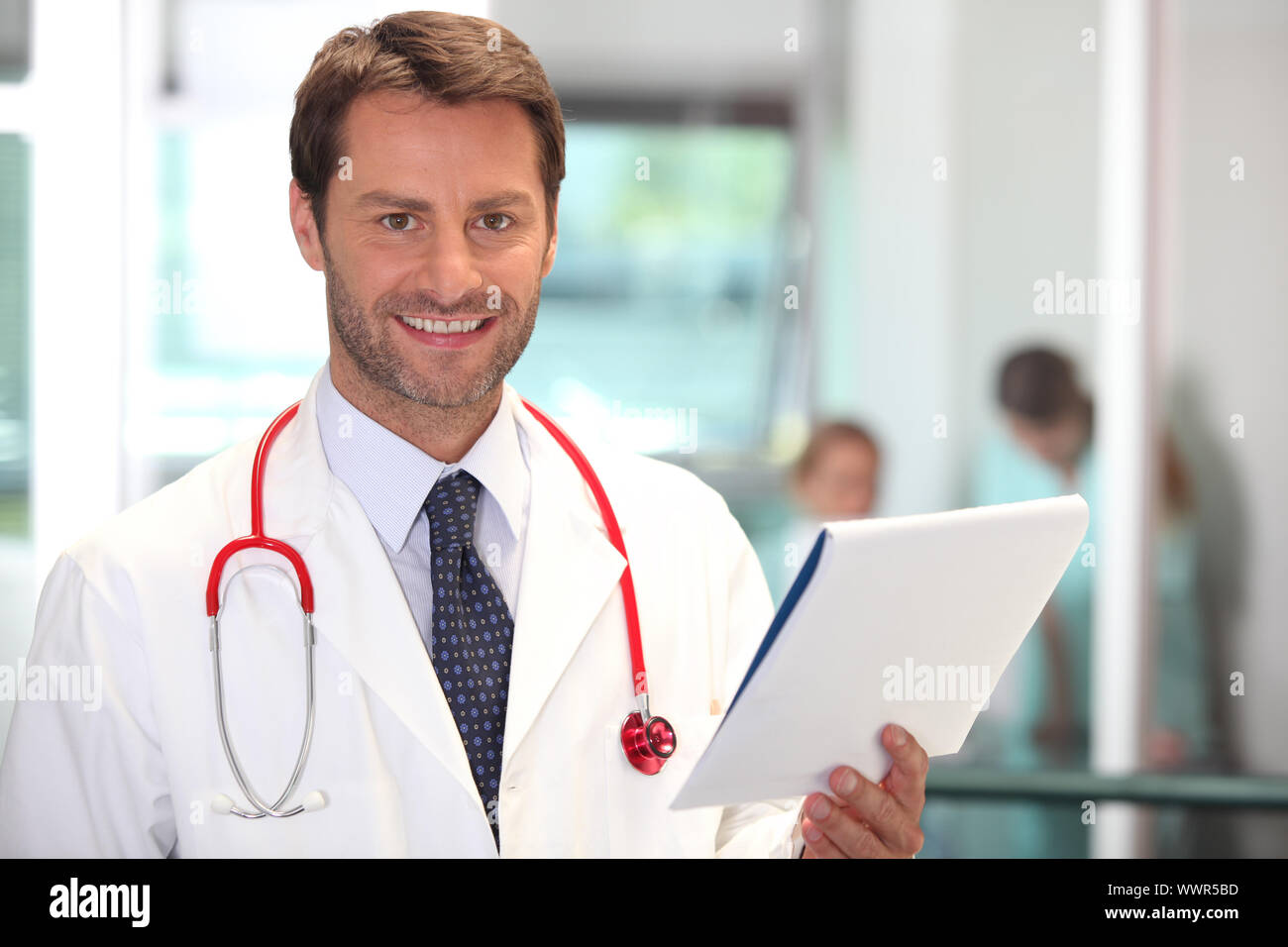 Hospital doctor checking patient notes Stock Photo - Alamy