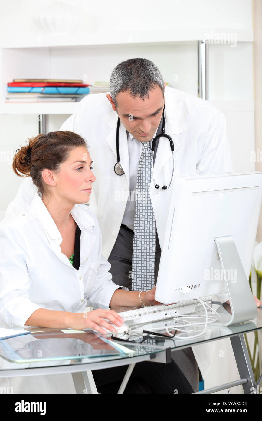 Doctors looking at a computer Stock Photo - Alamy