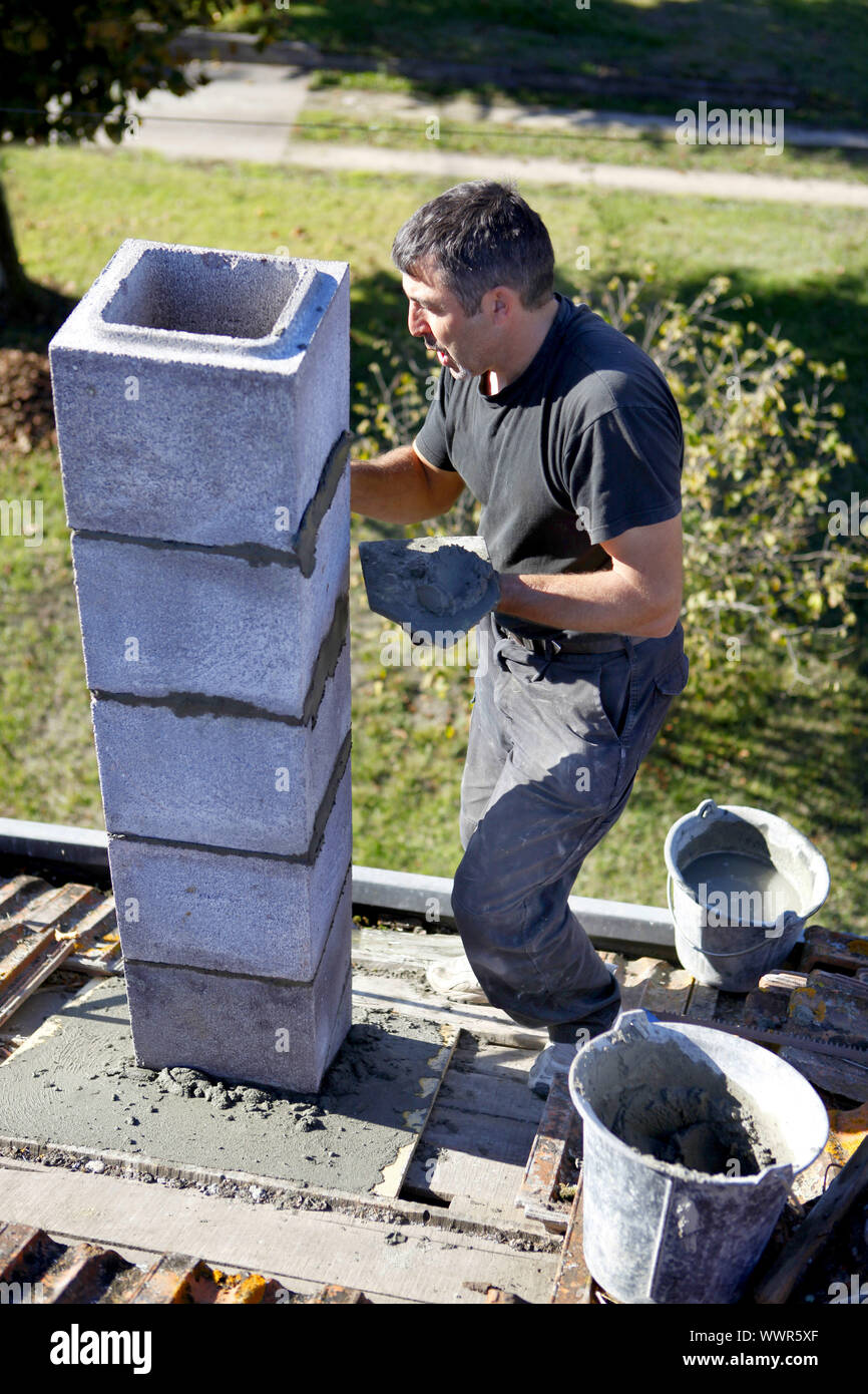 Mason building chimney Stock Photo - Alamy