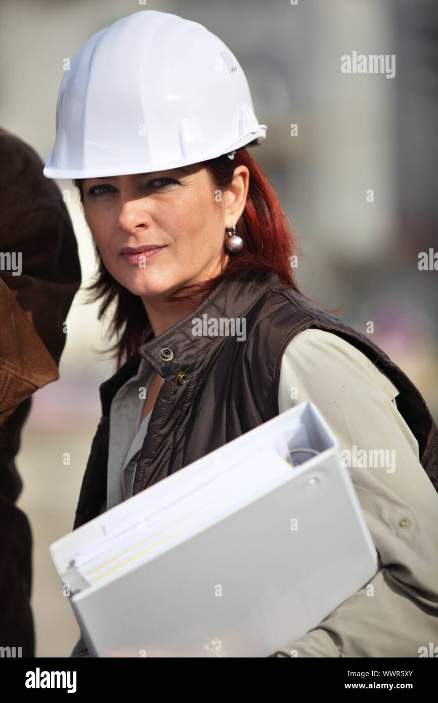 An engineer holding a binder and wearing a safety hat Stock Photo - Alamy