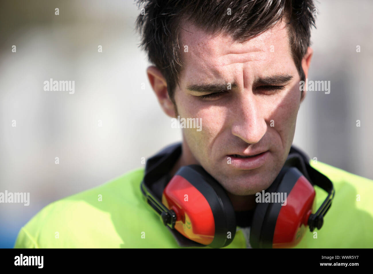 Worker on construction site wearing ear muffs Stock Photo - Alamy