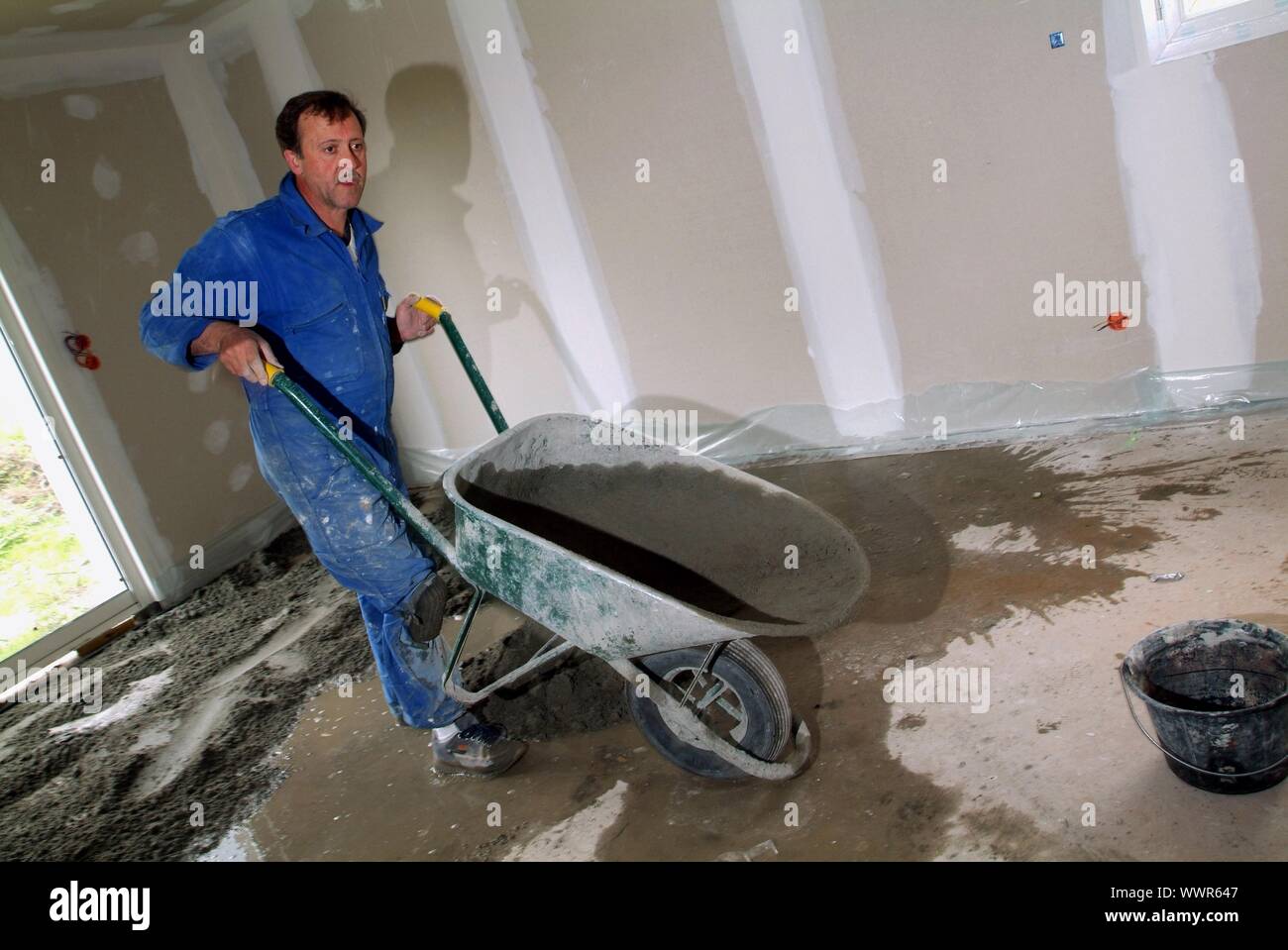 Mason tipping up wheelbarrow Stock Photo - Alamy
