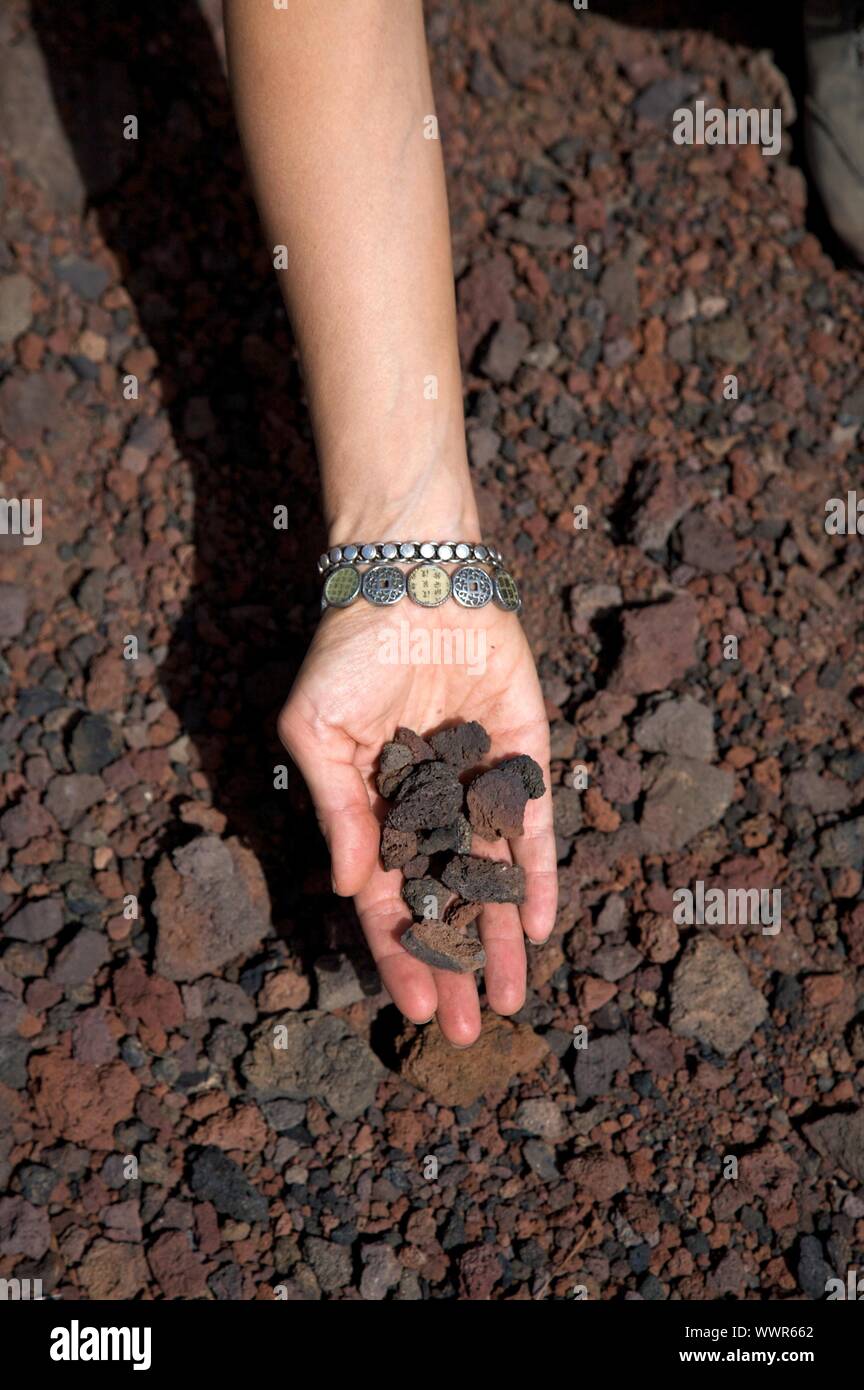 woman hand pick up volcanic stones Stock Photo - Alamy