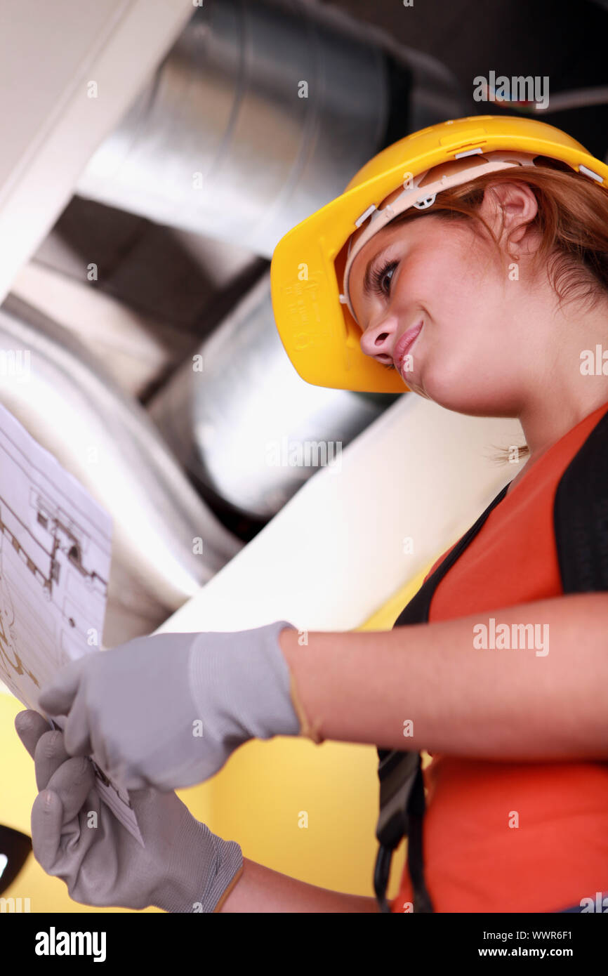 Tradeswoman reading a blueprint Stock Photo - Alamy