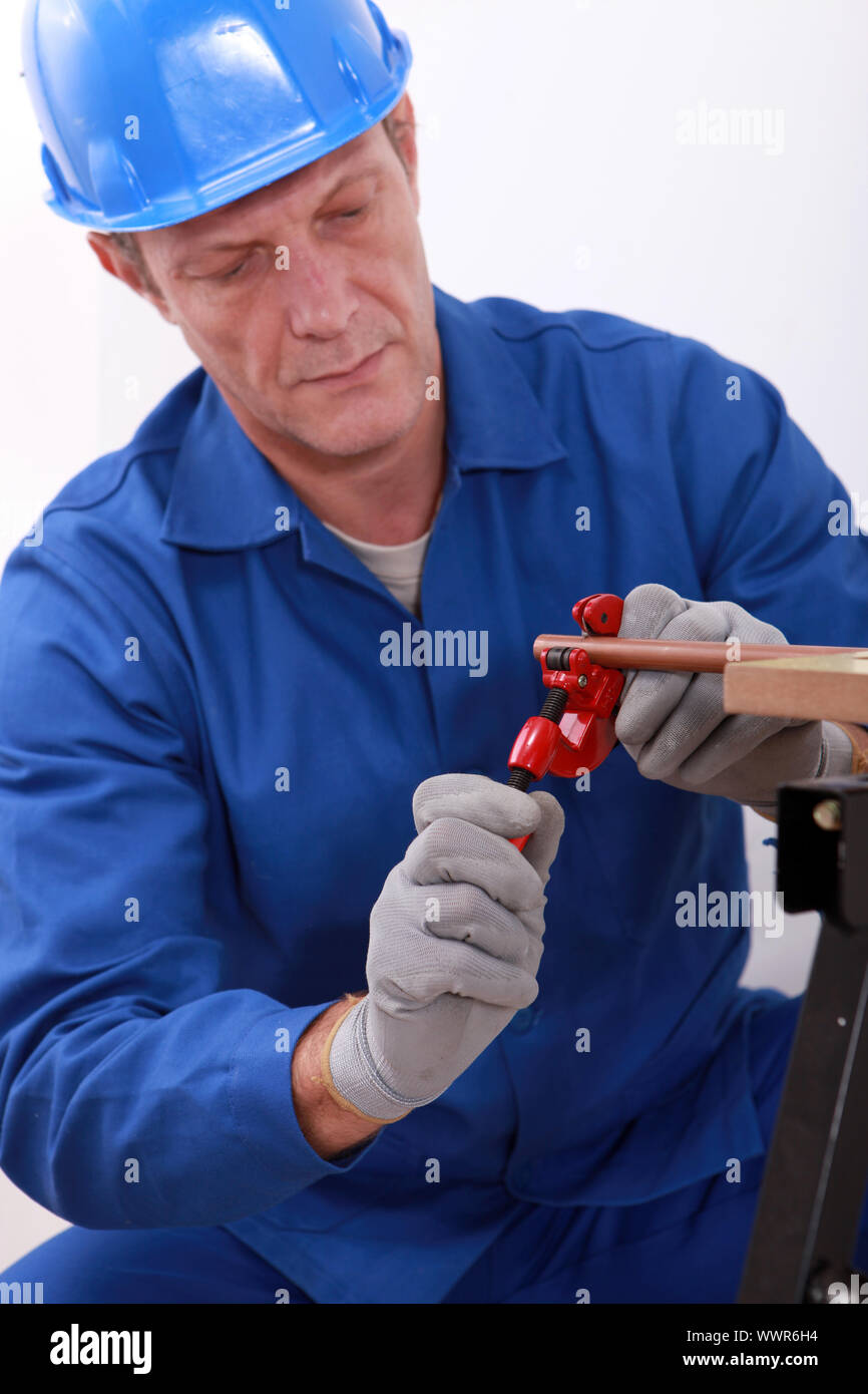 Laborer working on a copper pipe Stock Photo - Alamy