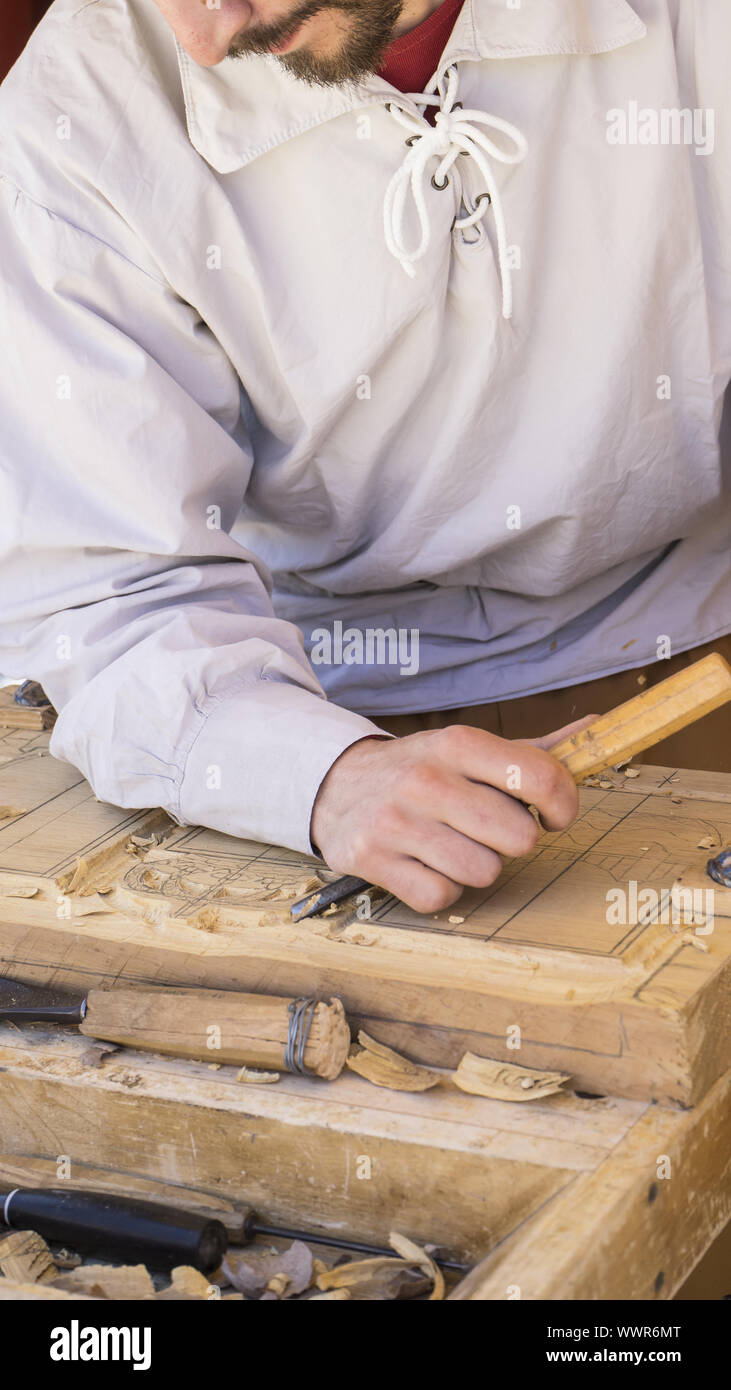 Lumber, craftsman carving wood in a medieval fair, carpentry tools ...