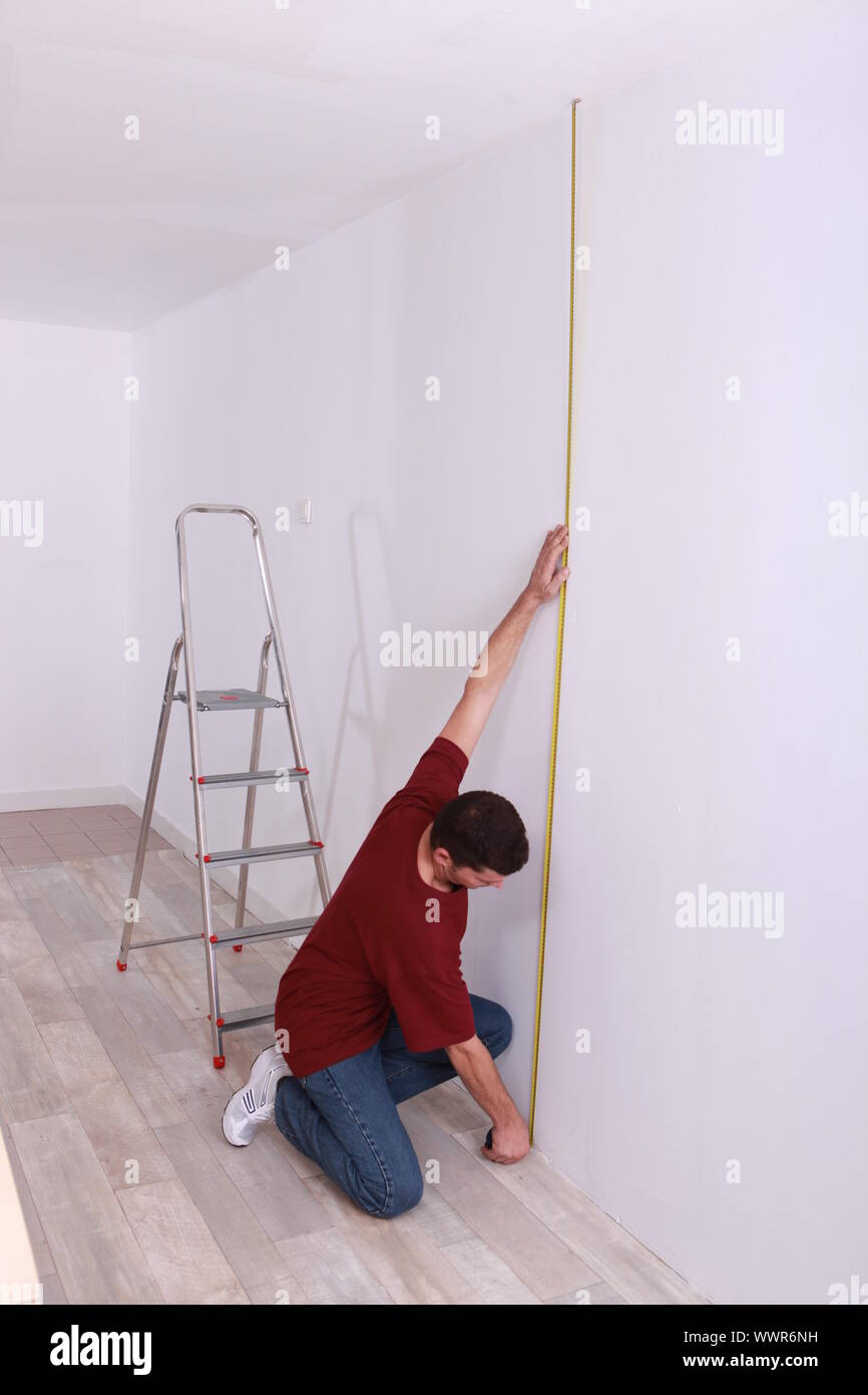 Man measuring wall Stock Photo - Alamy