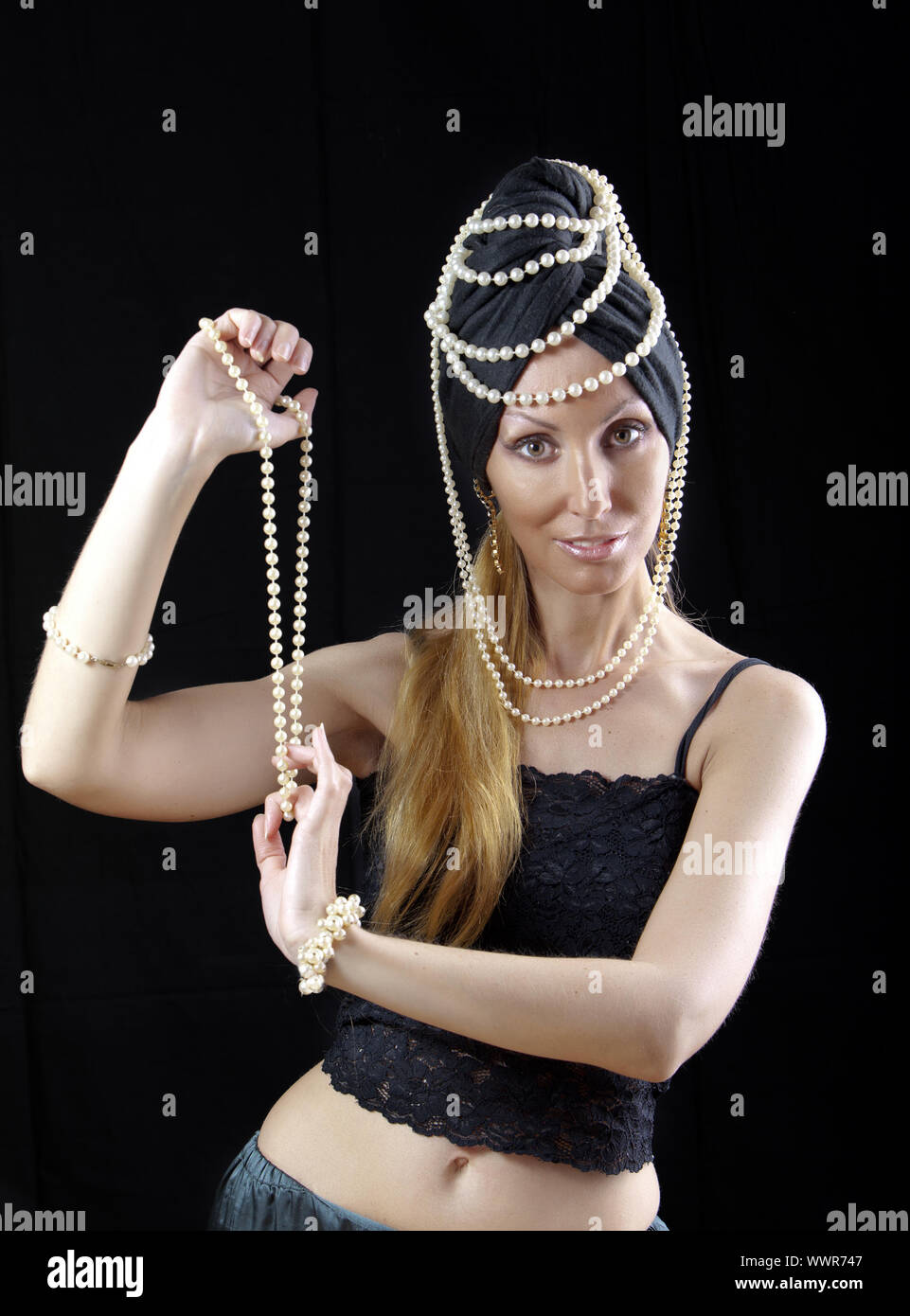 beautiful young blonde woman with long hair and a pearl dances an ...