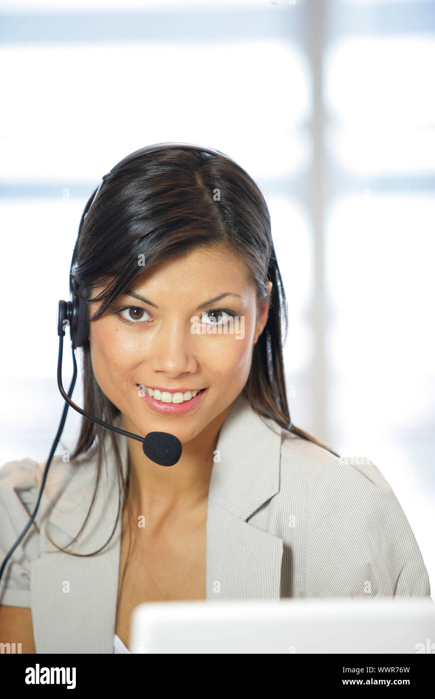 Portrait of a happy secretary wearing a headset Stock Photo - Alamy