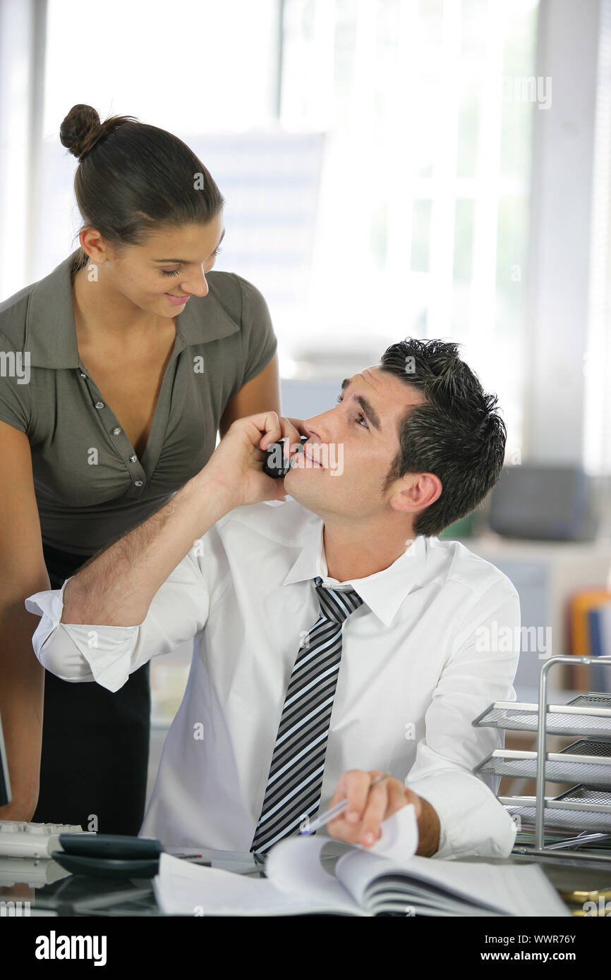 Woman asking her colleague a question Stock Photo - Alamy