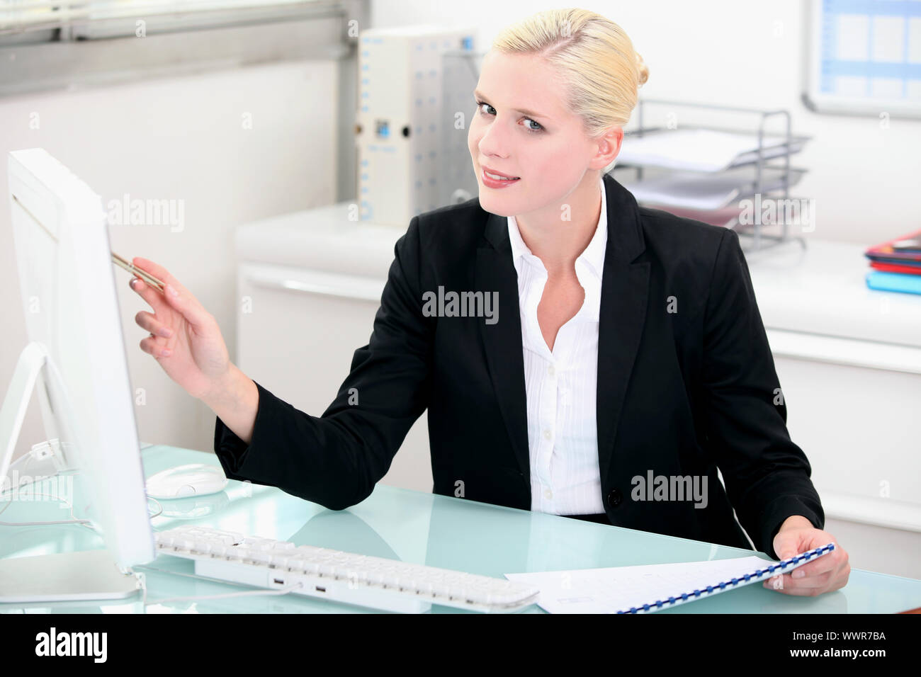 Blonde woman working at a clean modern desk Stock Photo - Alamy