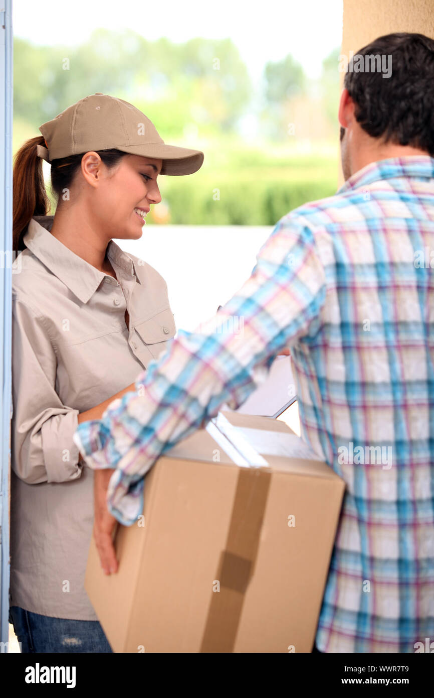 Man signing for a parcel at the front door Stock Photo - Alamy