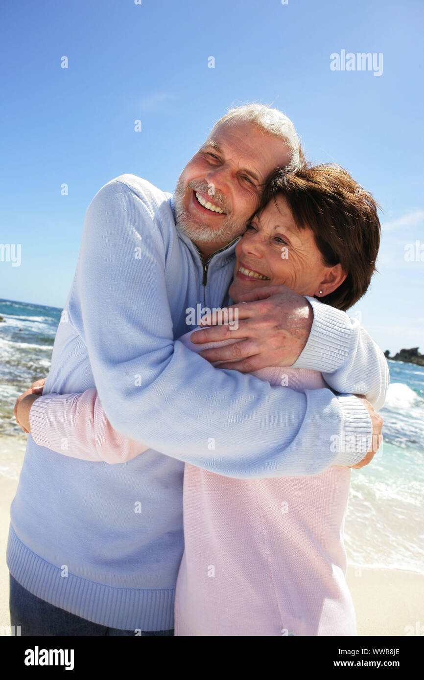 Older couple hugging on a beach Stock Photo - Alamy