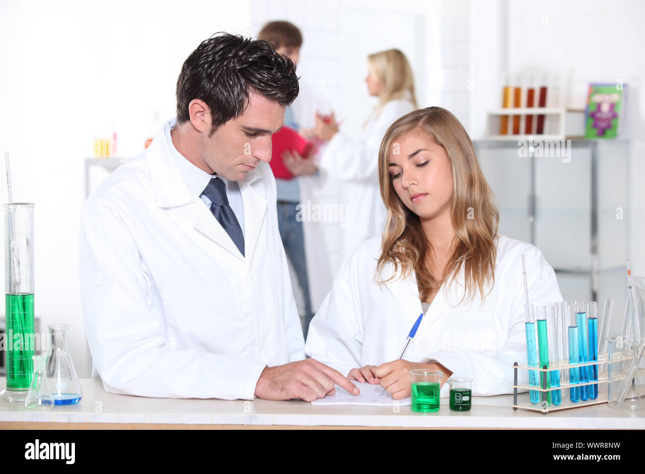 Science teacher helping student in laboratory Stock Photo - Alamy