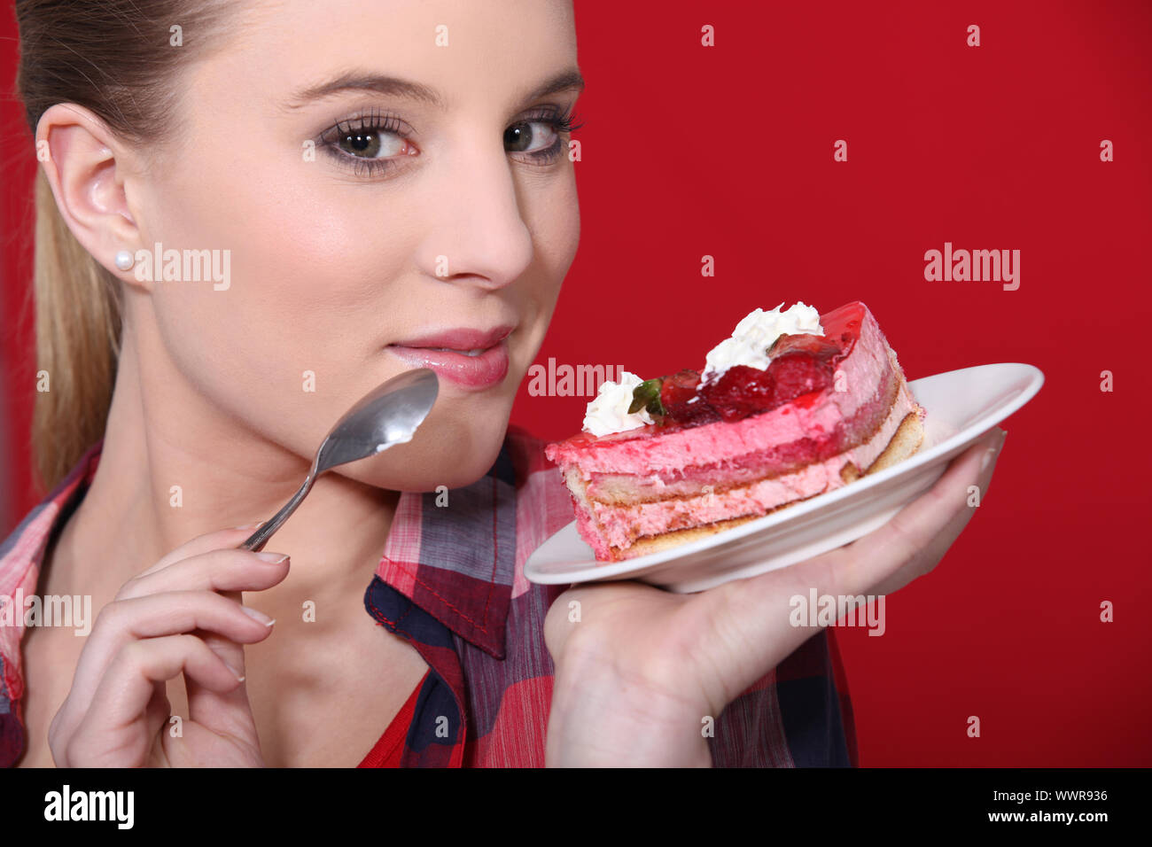 Woman holding up a scrumptious piece of cake Stock Photo - Alamy