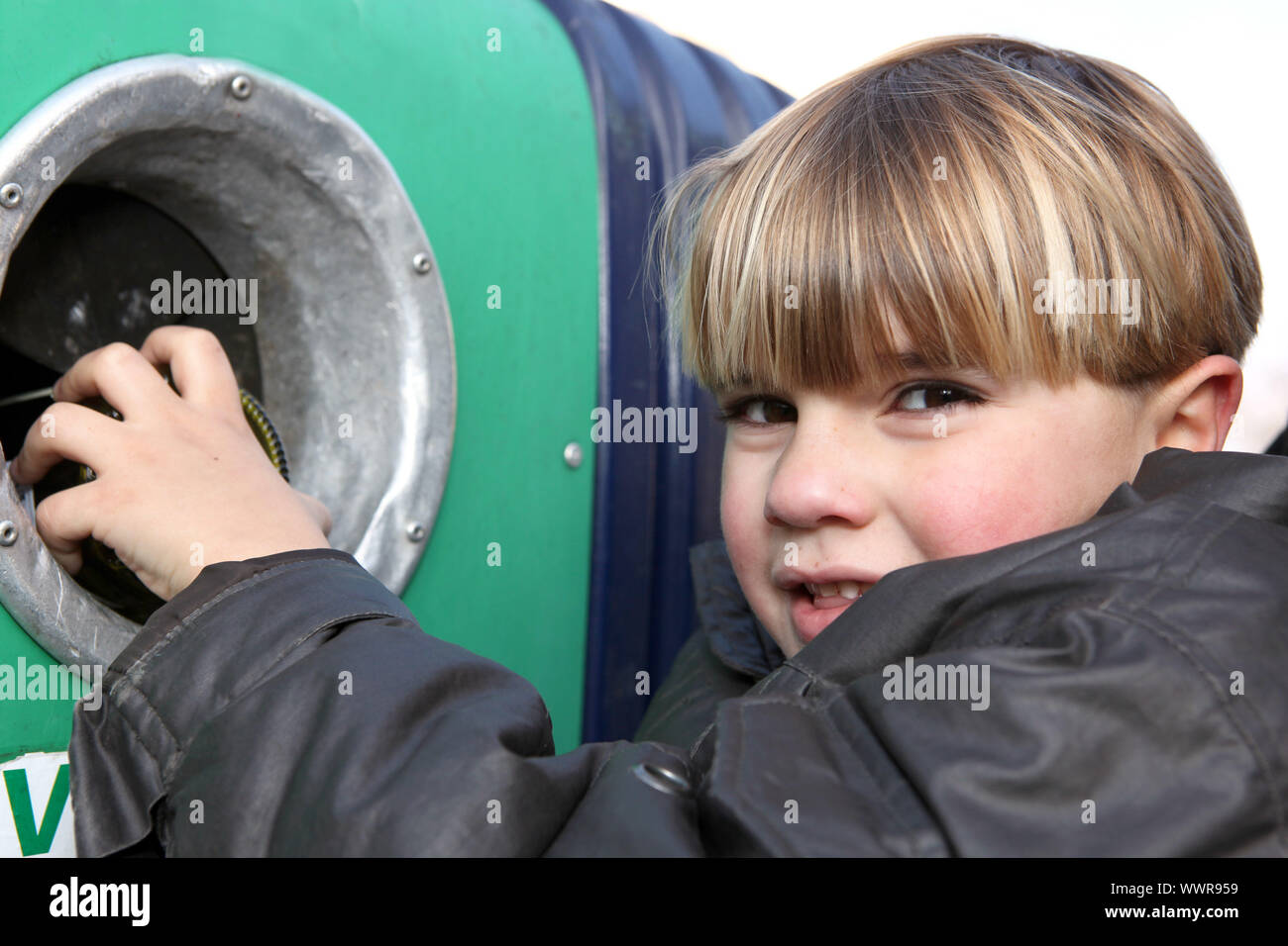 Little boy throwing a glass bottle in a container Stock Photo - Alamy