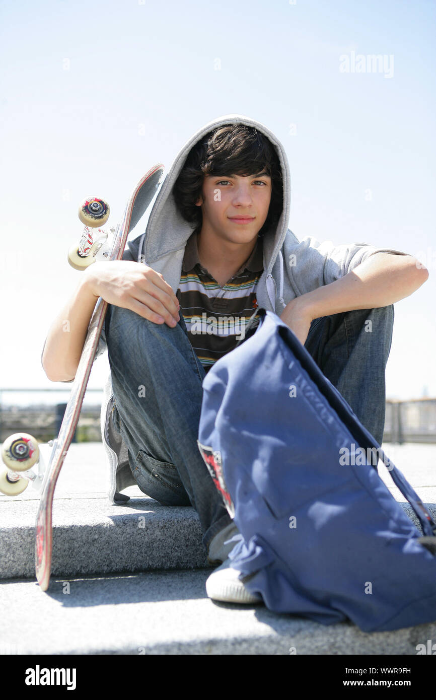 Boy sitting on a step with skateboard Stock Photo - Alamy