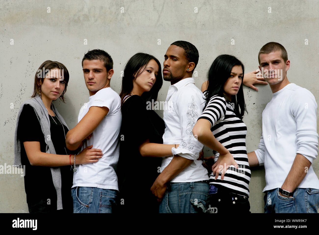Trendy young people gathered by wall Stock Photo - Alamy