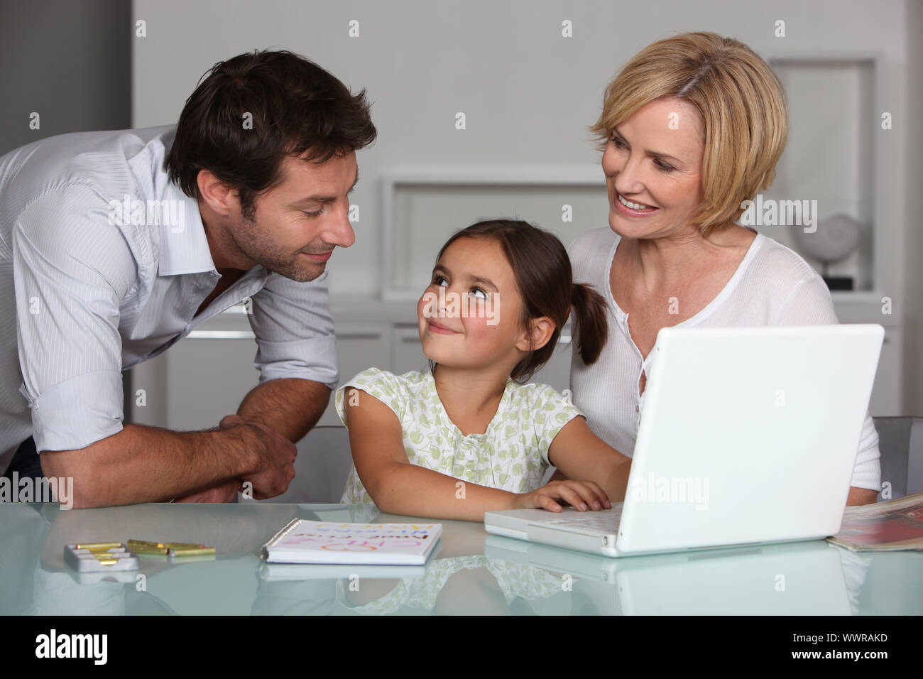 Parents and young daughter at laptop computer Stock Photo - Alamy