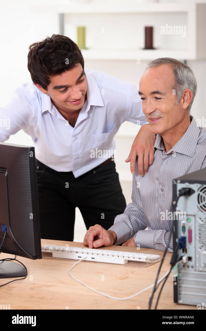 Son helping father with computer Stock Photo - Alamy