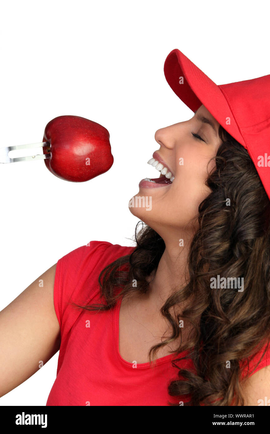 curly-haired brunette eating apple Stock Photo - Alamy