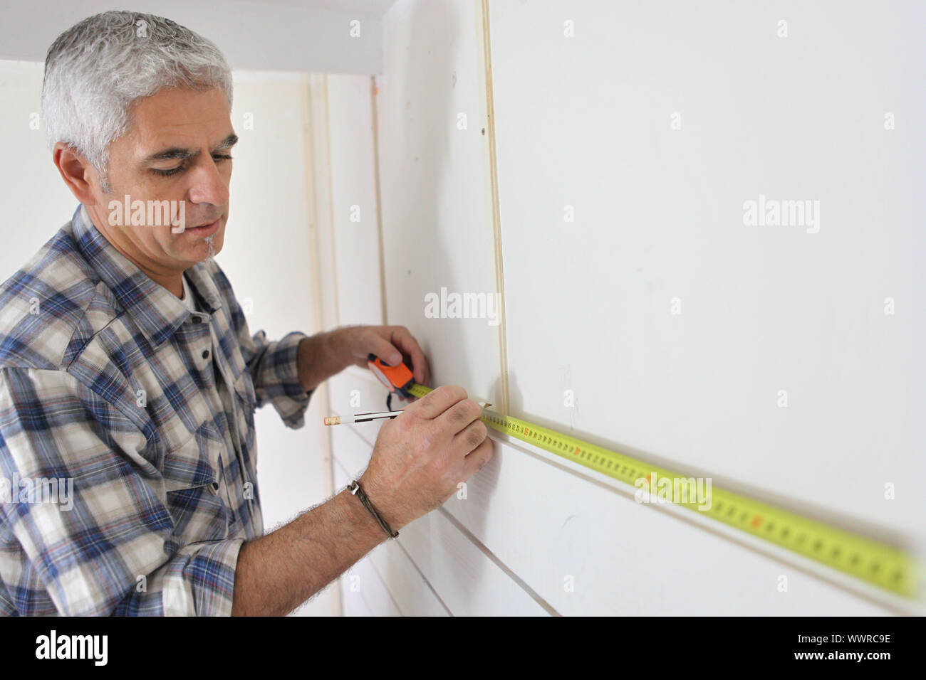 Man measuring wall Stock Photo - Alamy