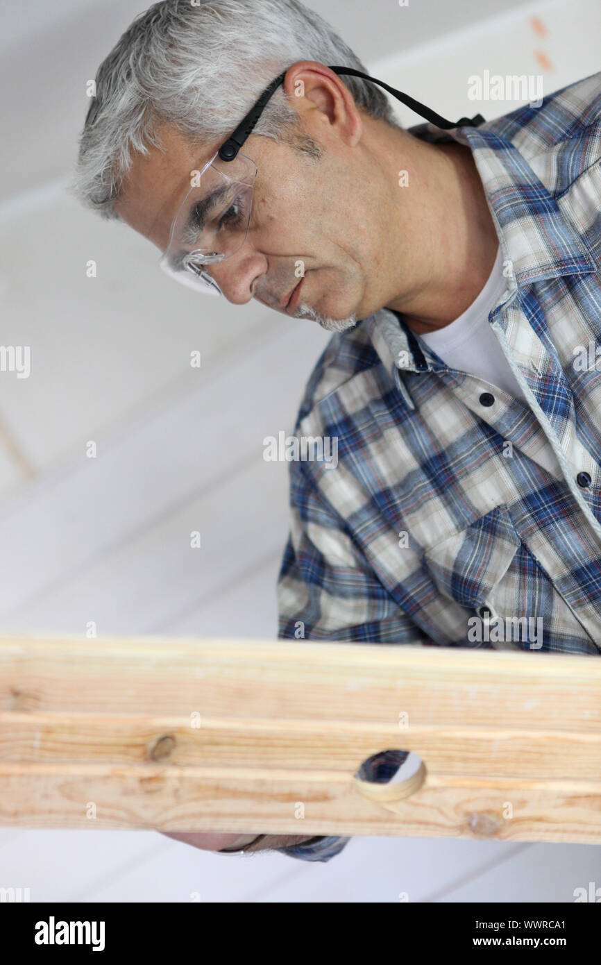 Carpenter inspecting wood Stock Photo - Alamy