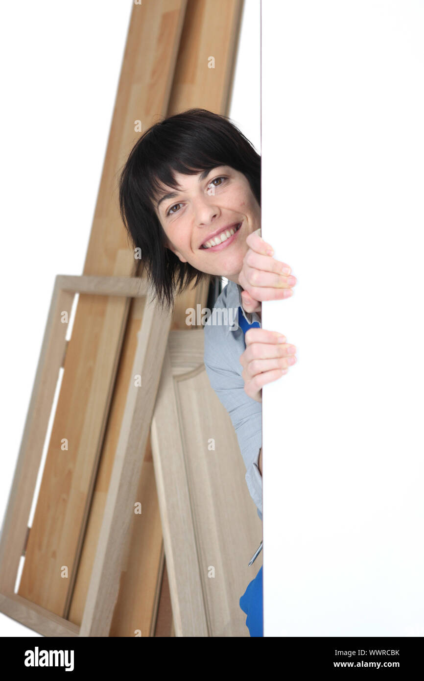 Woman peeking around a corner Stock Photo - Alamy