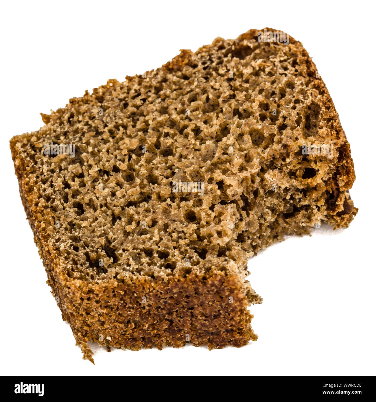 Bitten slice of bread made of dark flour, isolated on white background ...