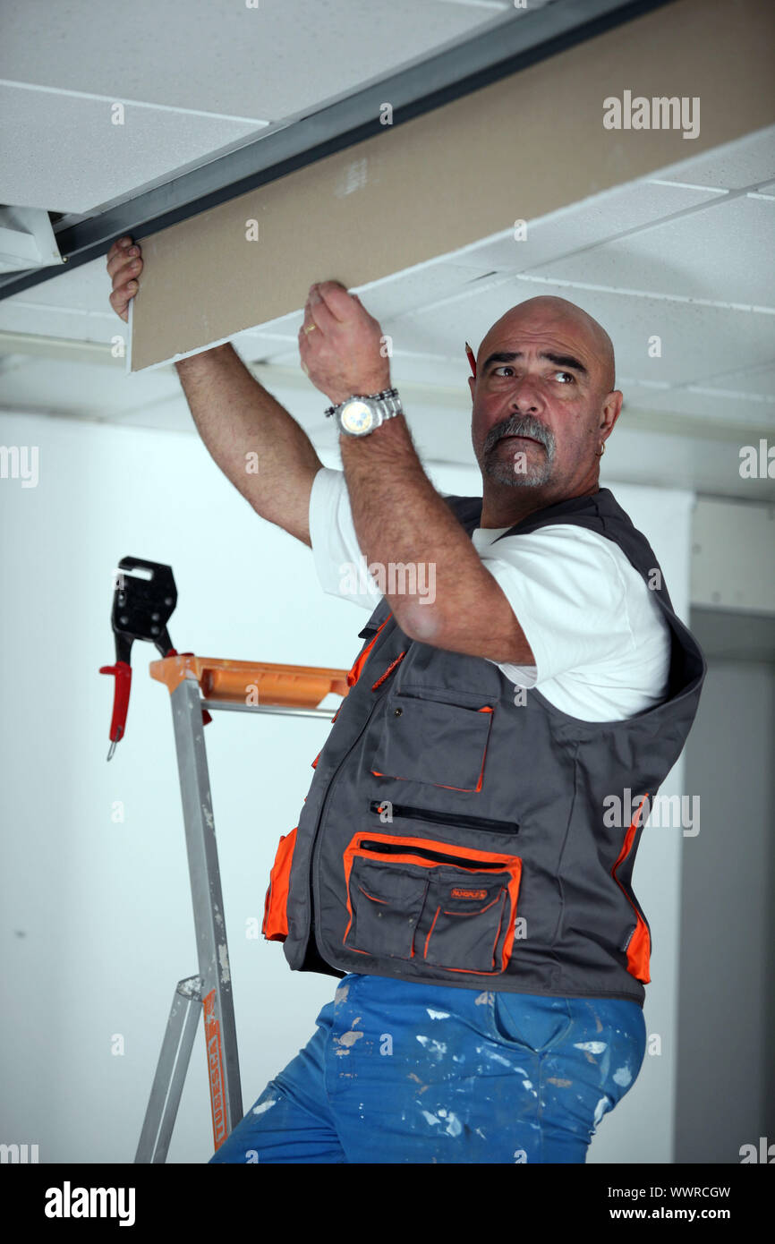 Manual worker repairing ceiling panel Stock Photo - Alamy