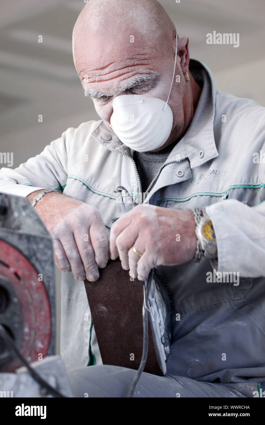 Dusty man changing the paper on an electric sander Stock Photo - Alamy