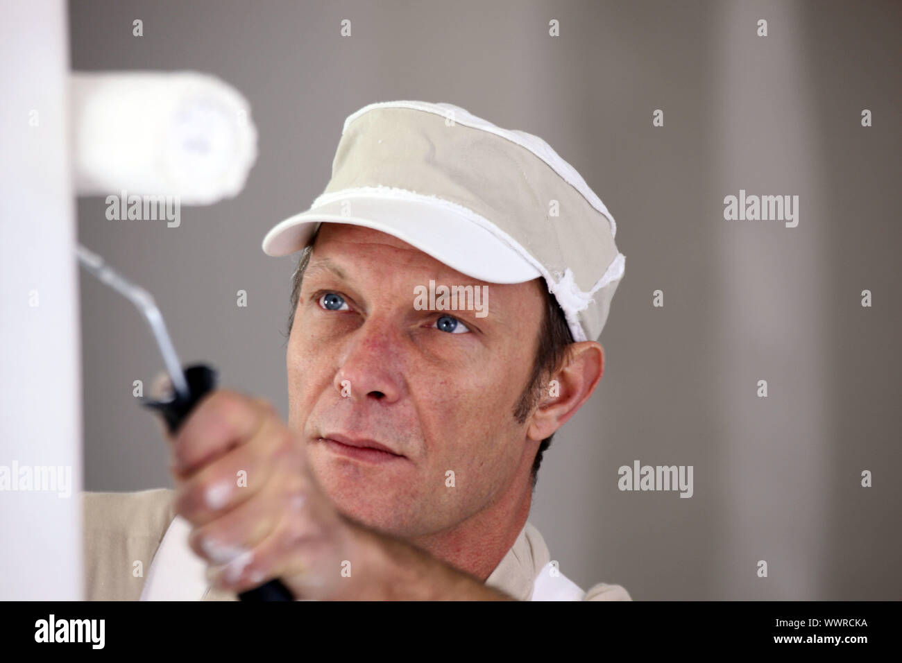 Man using paint roller on wall Stock Photo - Alamy