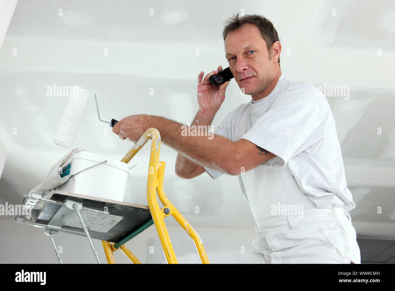 painter on ladder making a call Stock Photo - Alamy