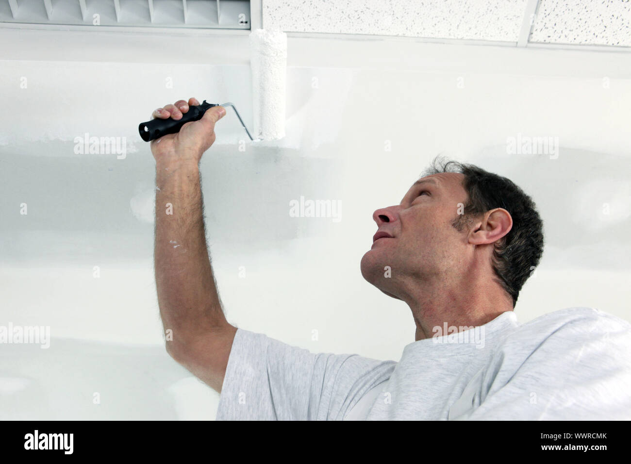 Painter using roller on ceiling Stock Photo - Alamy