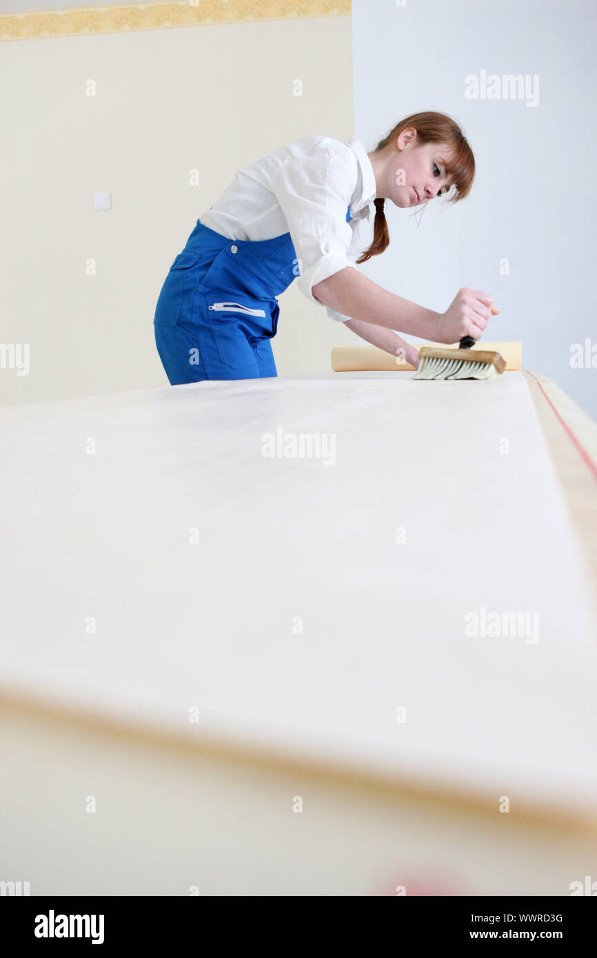 Woman pasting wallpaper Stock Photo - Alamy