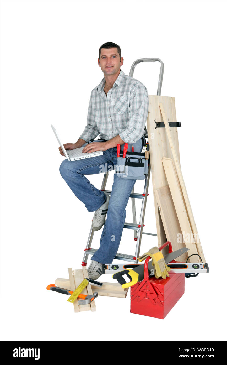 Handyman sitting on a ladder with laptop Stock Photo - Alamy