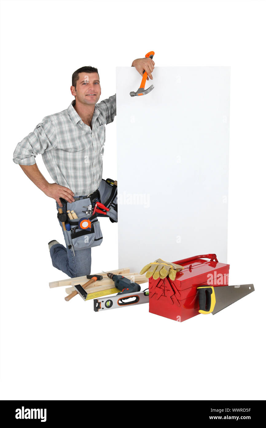 Handyman with a board left blank for your message Stock Photo - Alamy