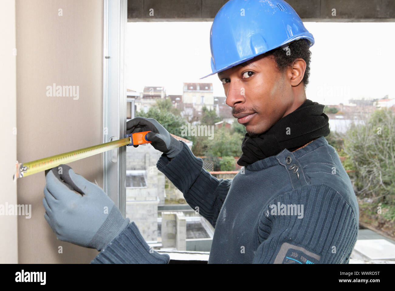 Manual worker measuring interior wall Stock Photo - Alamy