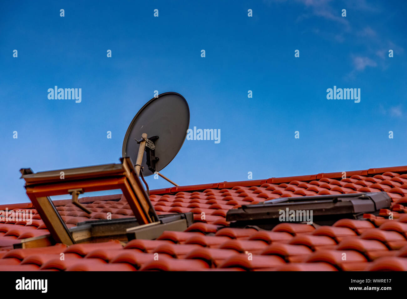 Red roof tiles on a house with blue summer sky Stock Photo - Alamy
